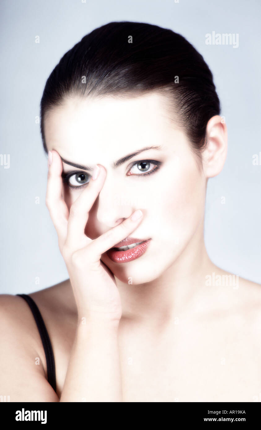 indoor studio close up woman 25 30 young brunette smile smiling strap straps hand touch face ...