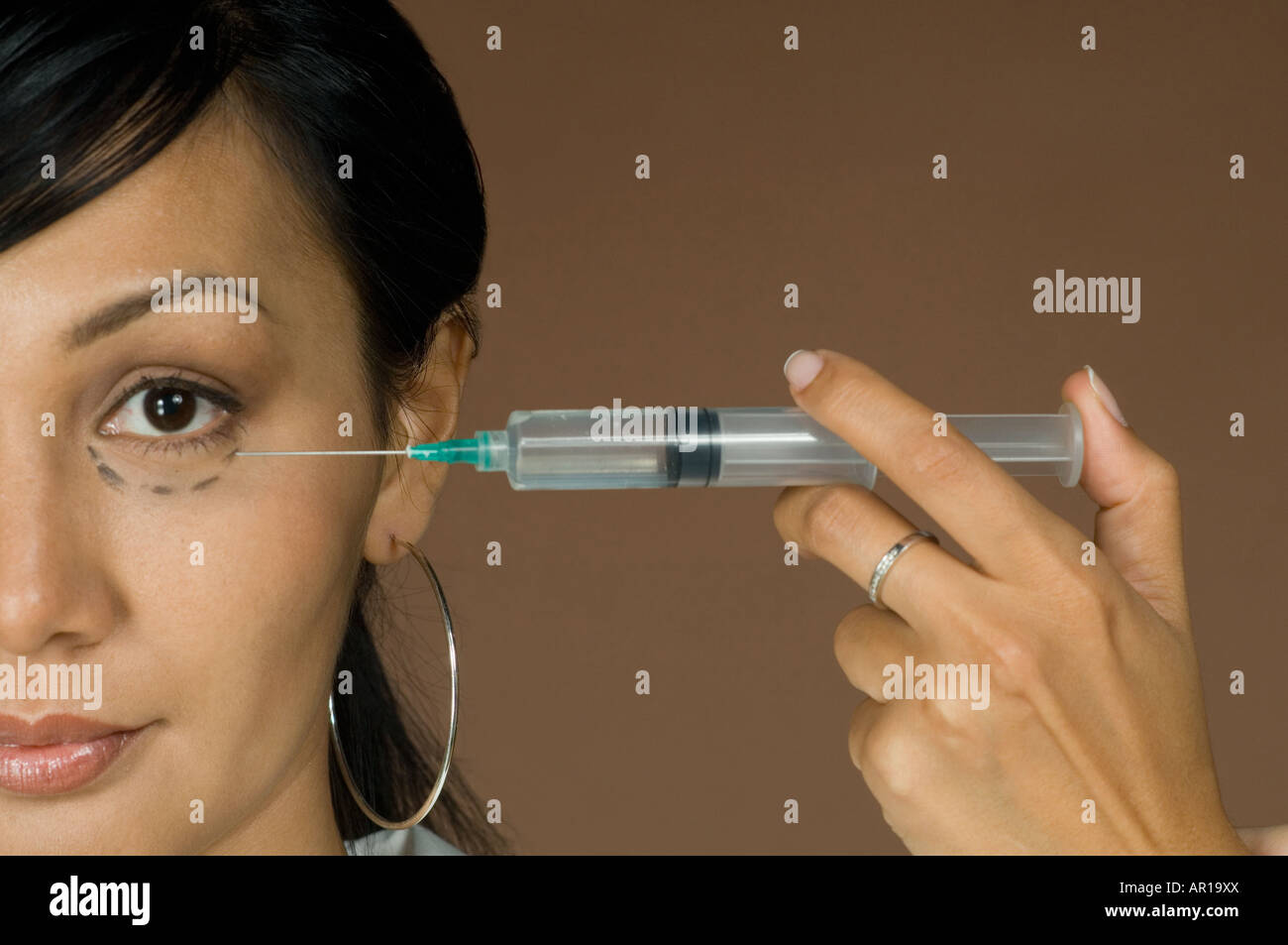 Young woman holding a syringe Stock Photo - Alamy