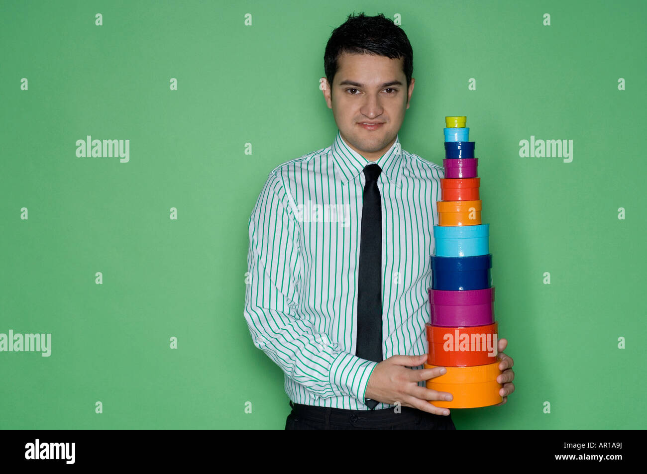 Young man holding a stack of colorful boxes Stock Photo - Alamy