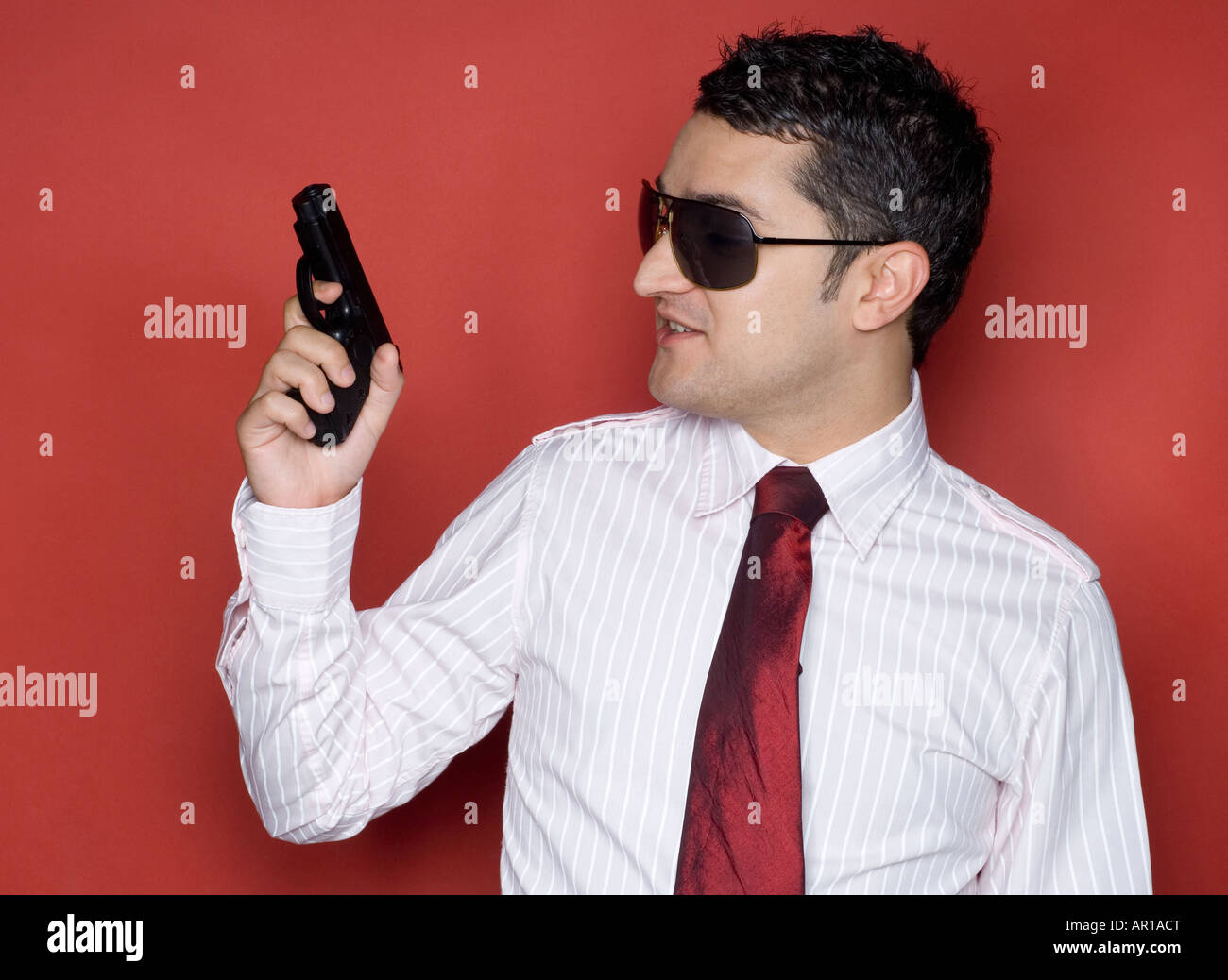 Portrait of a young man holding a gun Stock Photo - Alamy