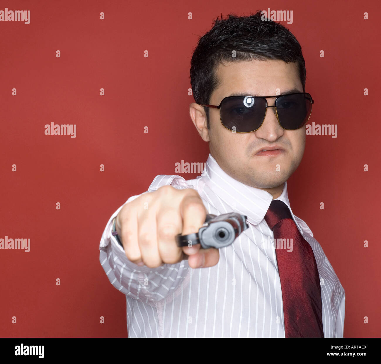 Portrait of a young man holding a gun Stock Photo - Alamy