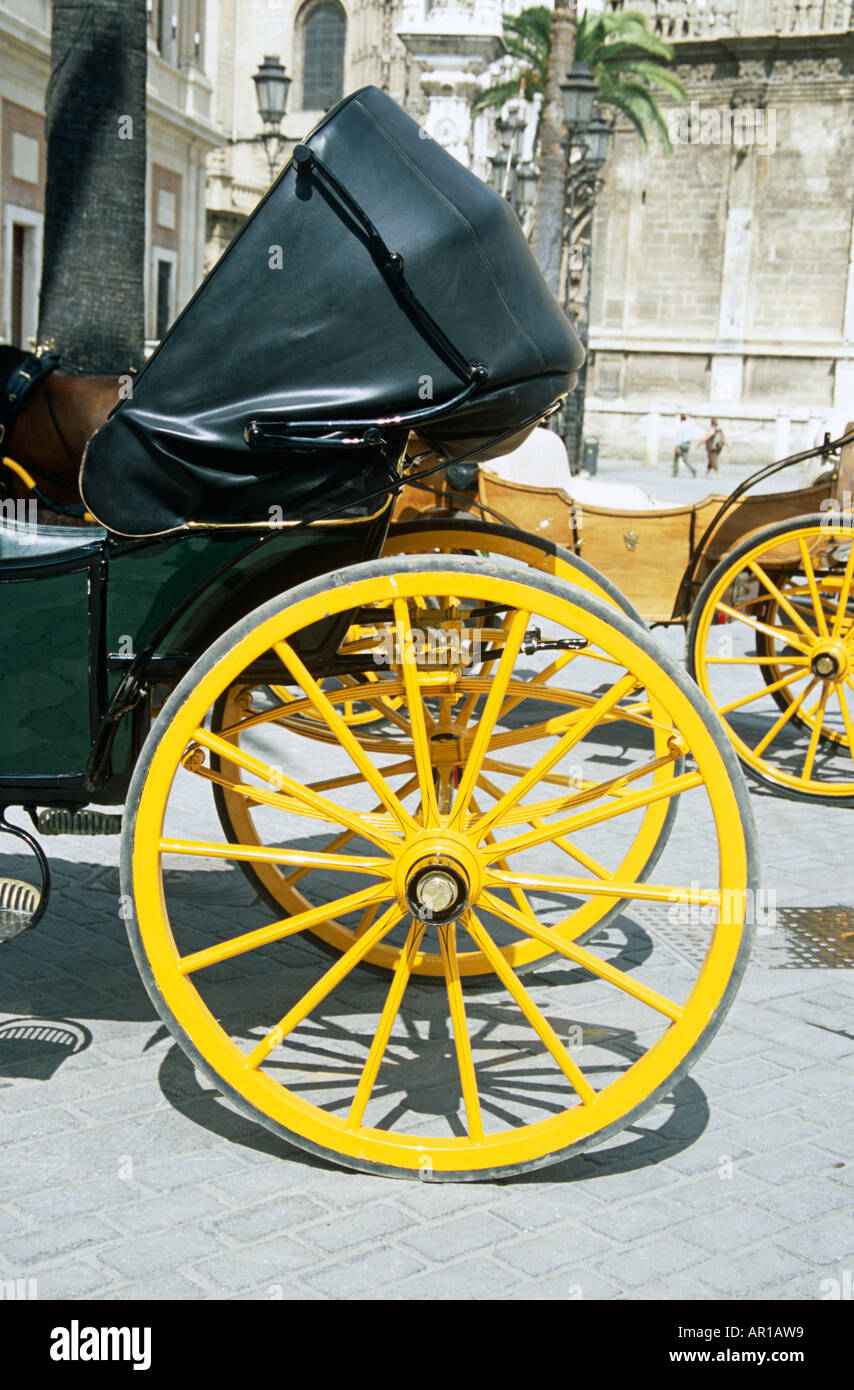 Yellow brightly painted wheel of horse drawn carriage in Plaza Virgen ...