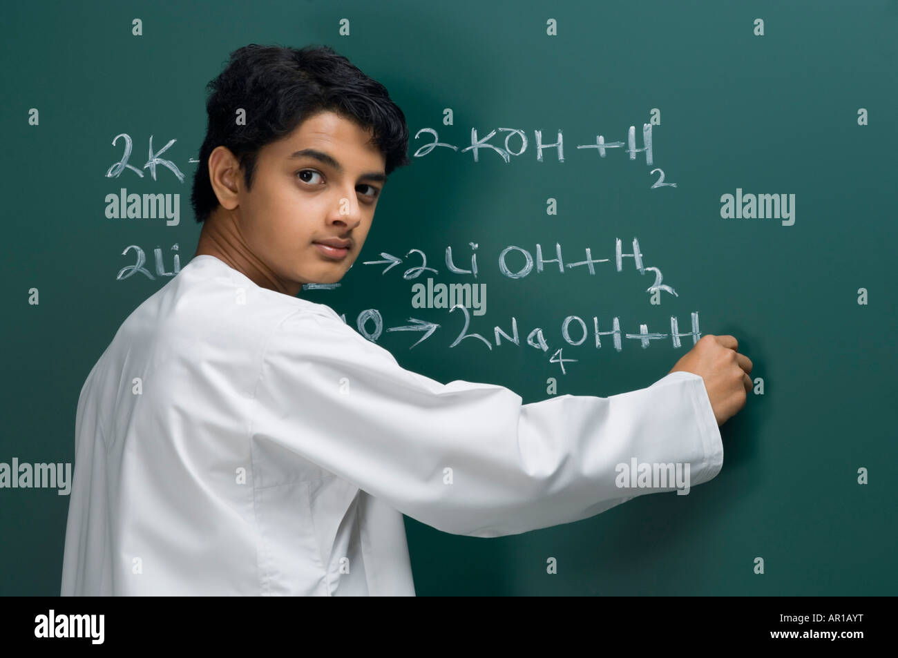 Teenage boy solving equations on blackboard Stock Photo - Alamy