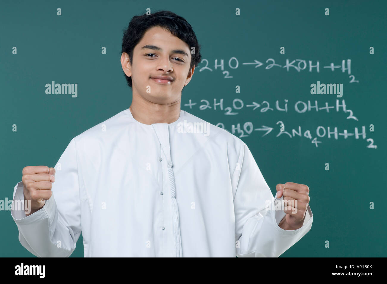 Teenage boy gesturing by blackboard, portrait Stock Photo - Alamy