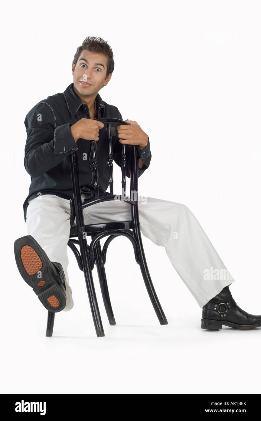 Young man sitting on chair, portrait Stock Photo - Alamy