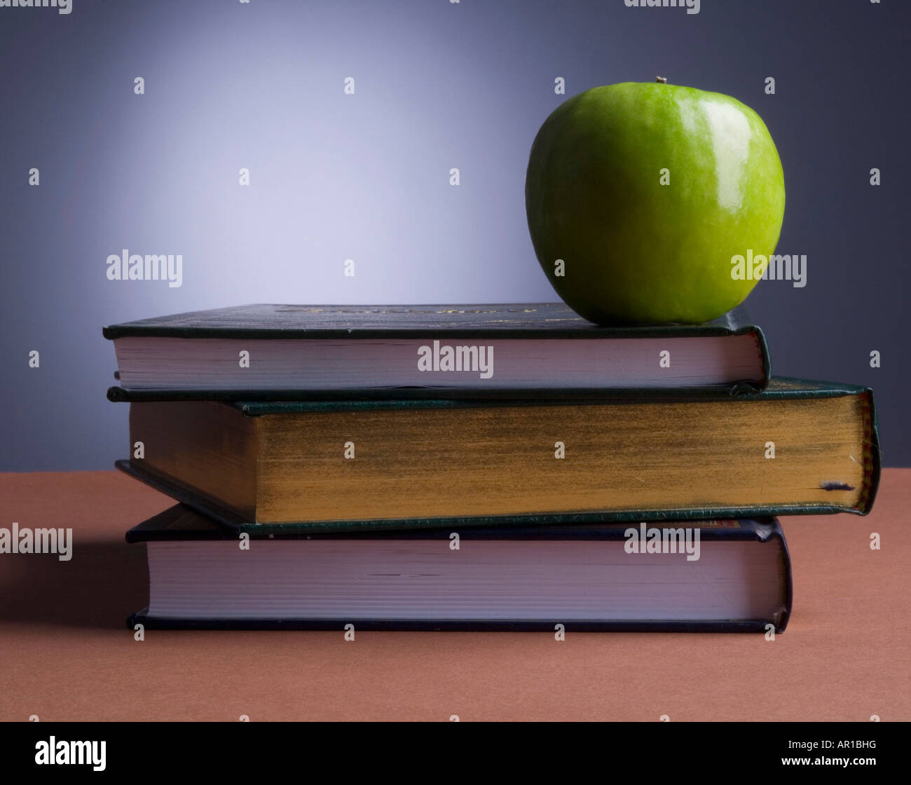 Apple on top of books Stock Photo - Alamy