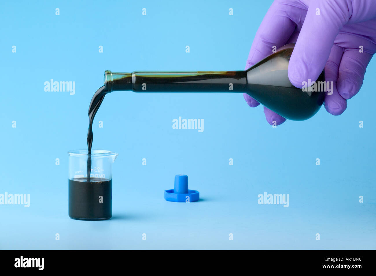 Crude oil being poured into a glass beaker Stock Photo - Alamy