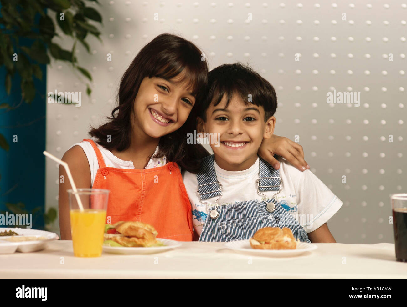 Two siblings eating their food Stock Photo - Alamy