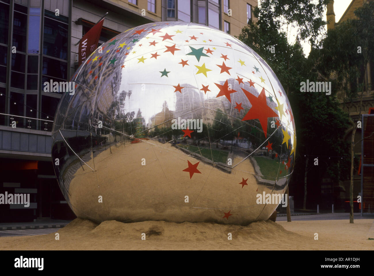 A sculpture, in the form of a giant metal ball, reflects buildings in ...