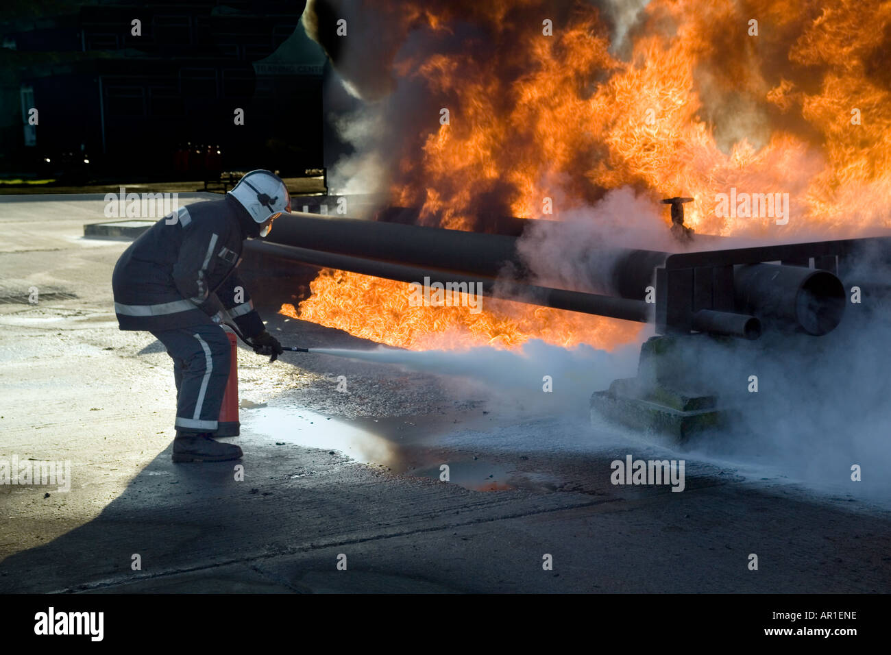 Fireman fighting indudtrial fire with powder extinguisher Stock Photo ...