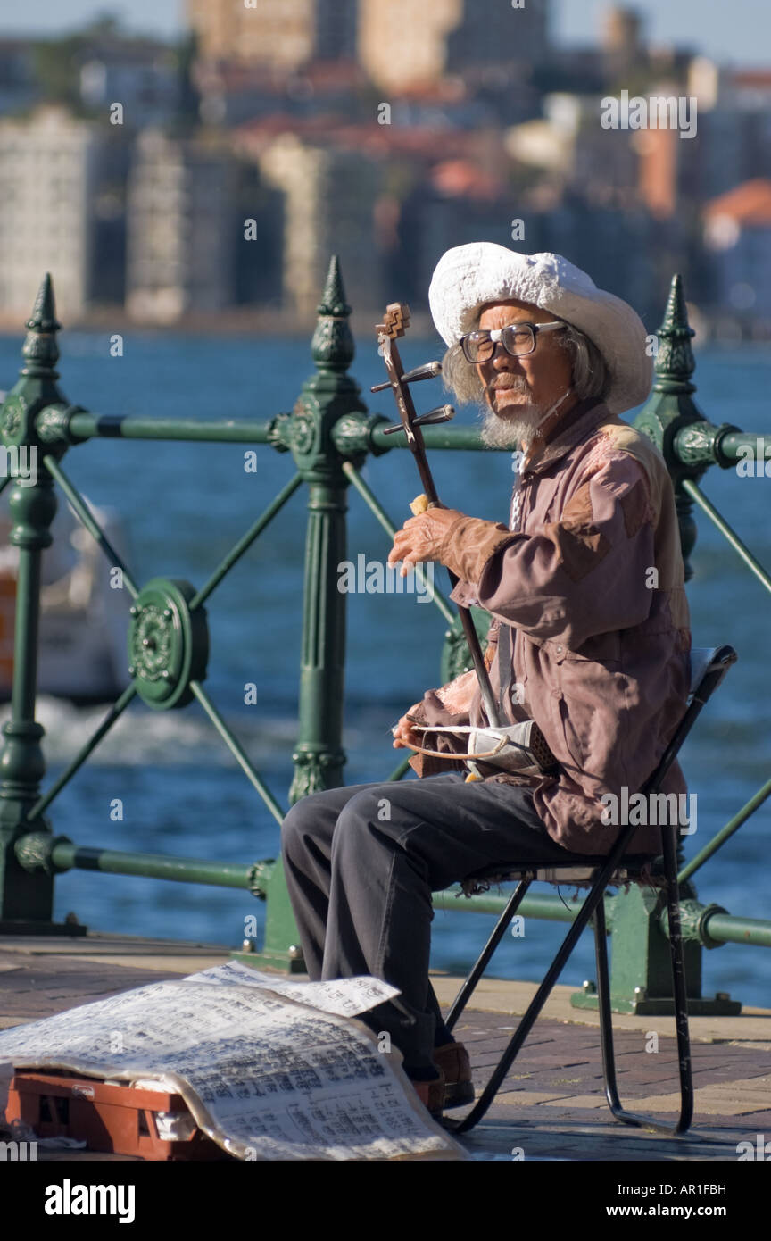 Elderly Chinese man playing an old Chinese string instrument, the erhu ...