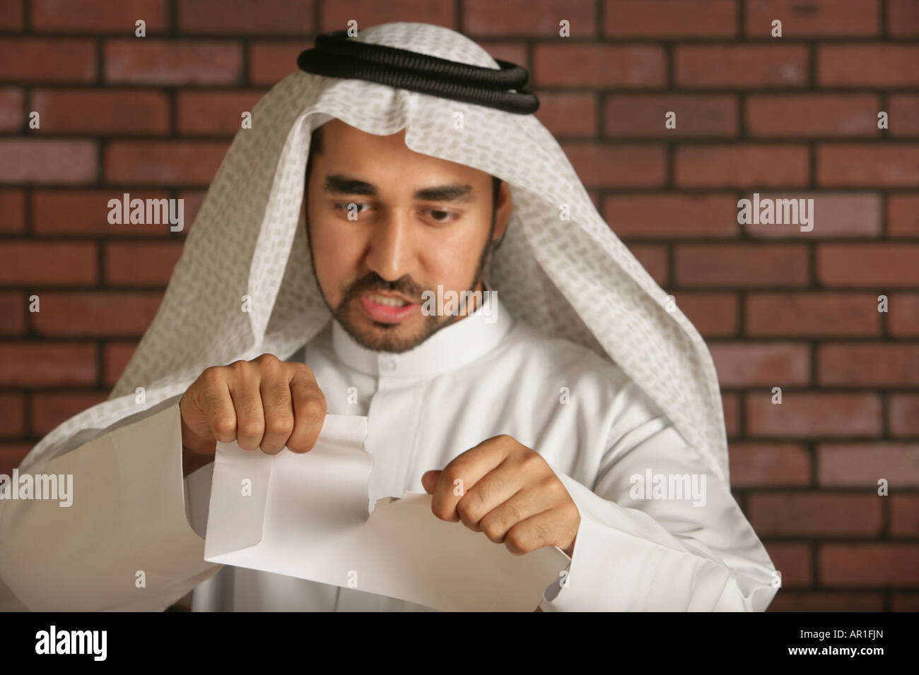 Arab Man tear off the paper Stock Photo - Alamy