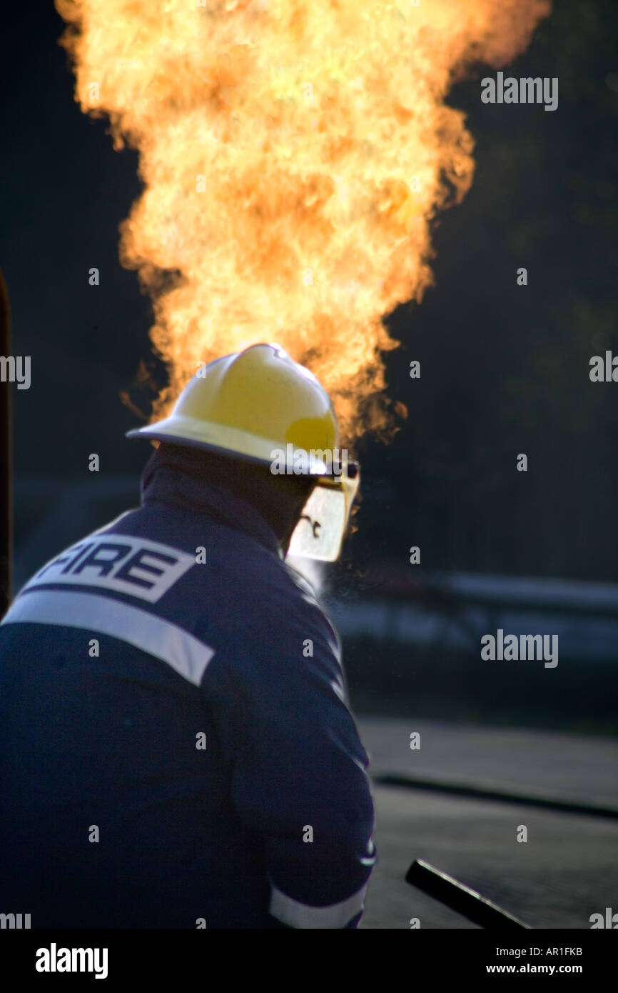Firemen advancing fire behind water hose shield protection Stock Photo ...