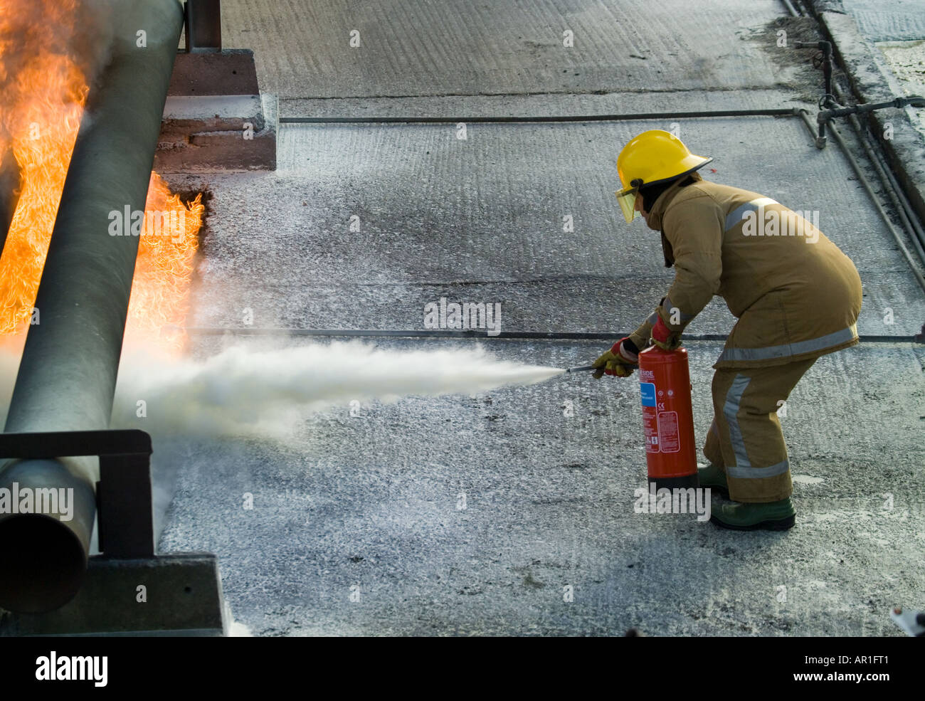Fireman fighting indudtrial fire with powder extinguisher Stock Photo ...