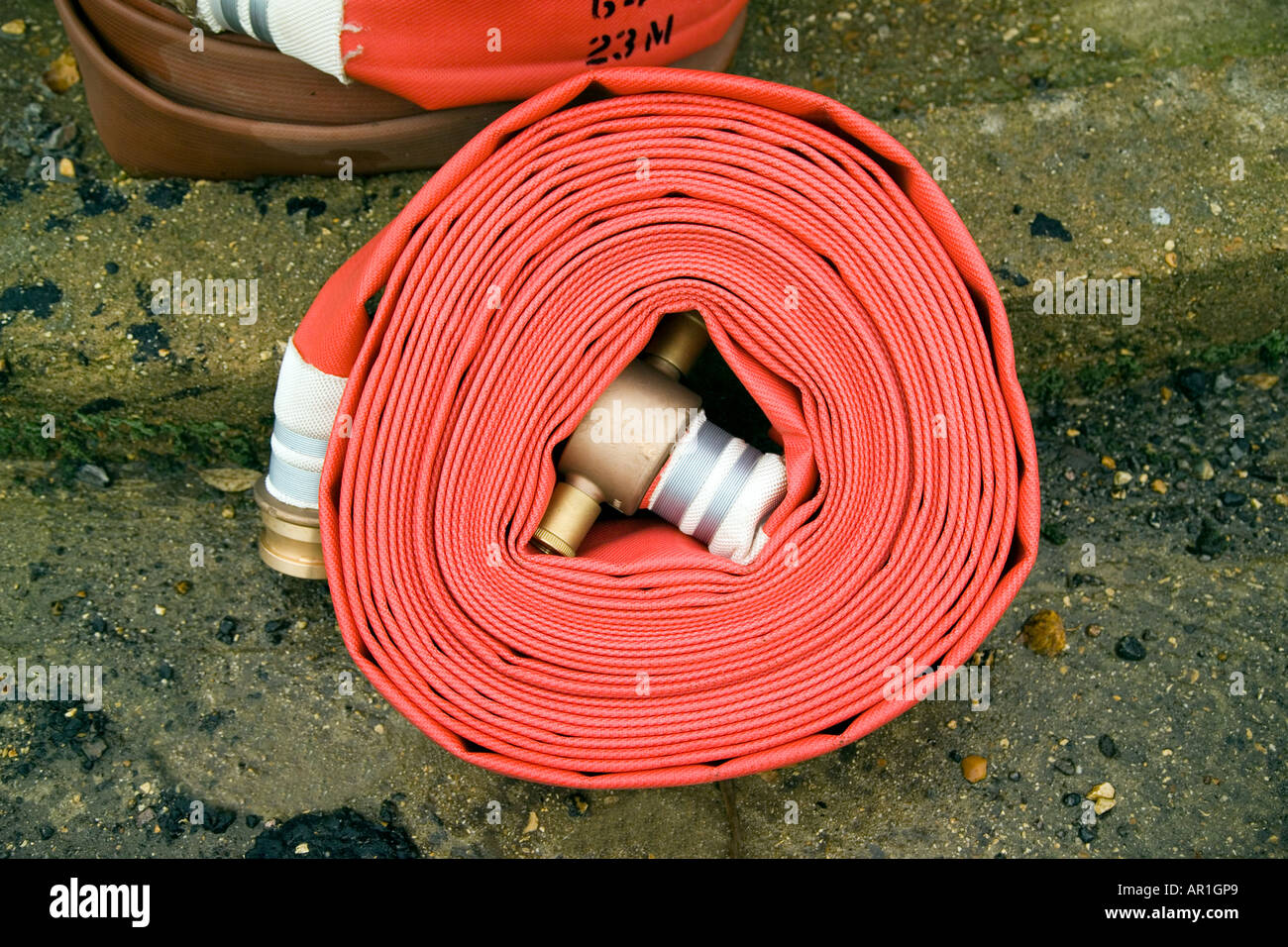 Coiled up red high pressure fire hose Stock Photo - Alamy