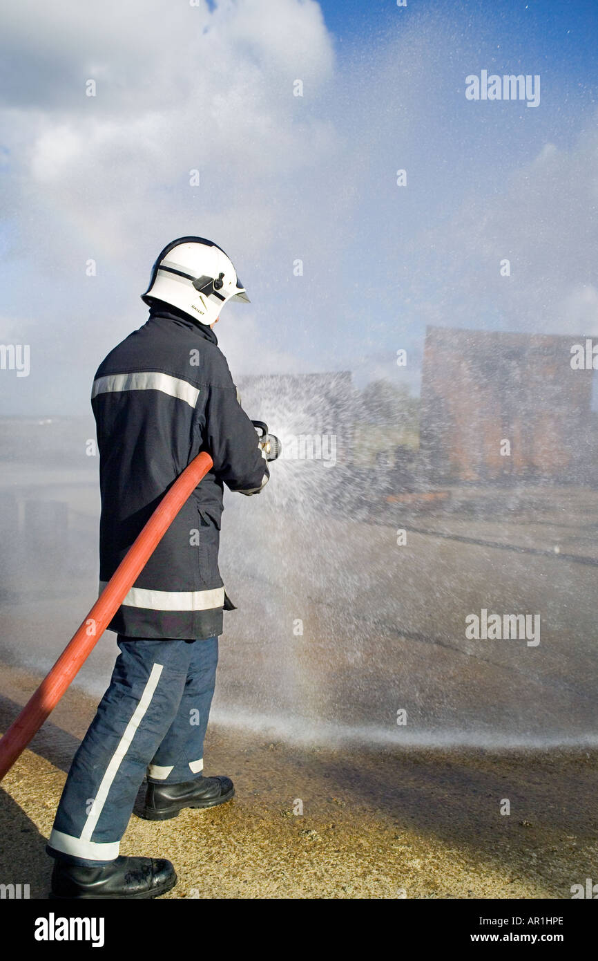 Firemen advancing fire behind water hose shield protection Stock Photo ...