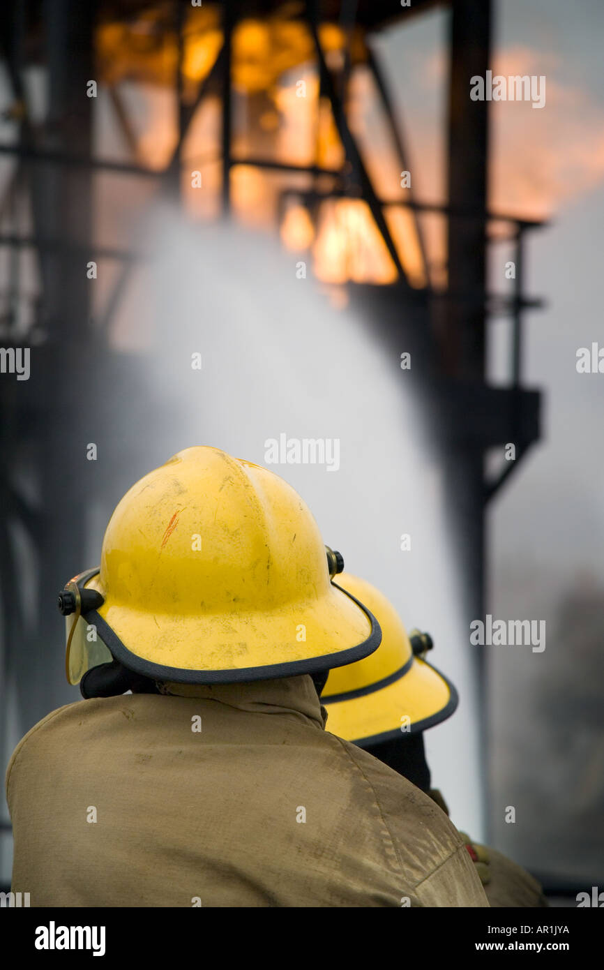 Firemen advancing fire behind water hose shield protection brave hi-res ...