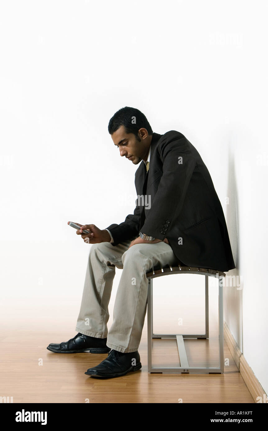 Young man sitting with a mobile phone Stock Photo - Alamy