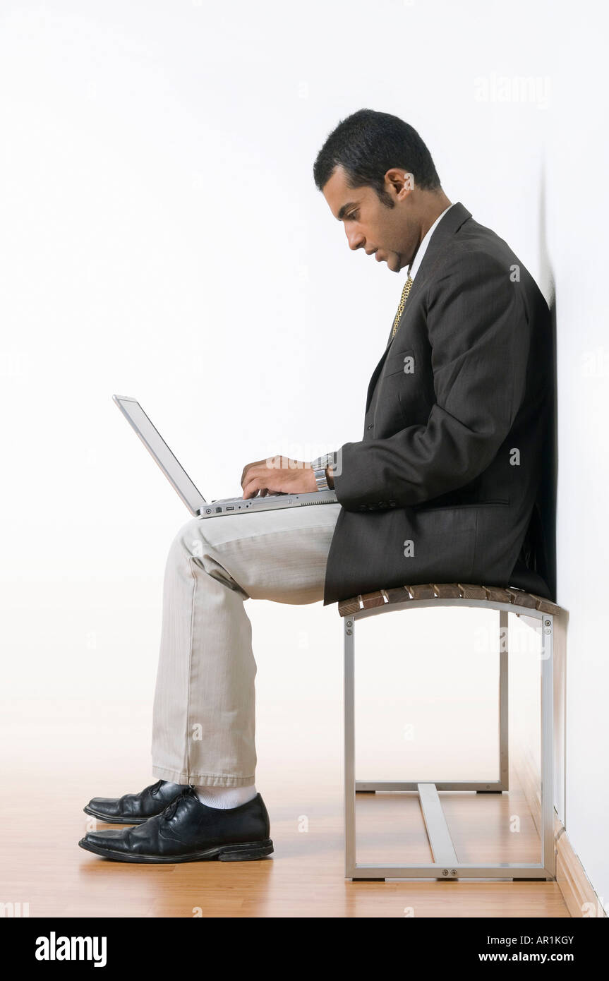 Young man sitting with a laptop computer Stock Photo - Alamy