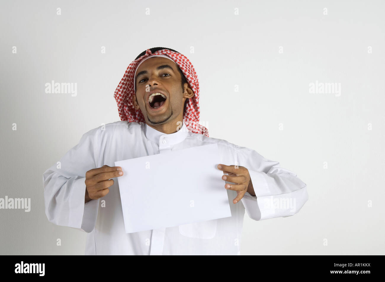Young Arab man showing a paper Stock Photo - Alamy