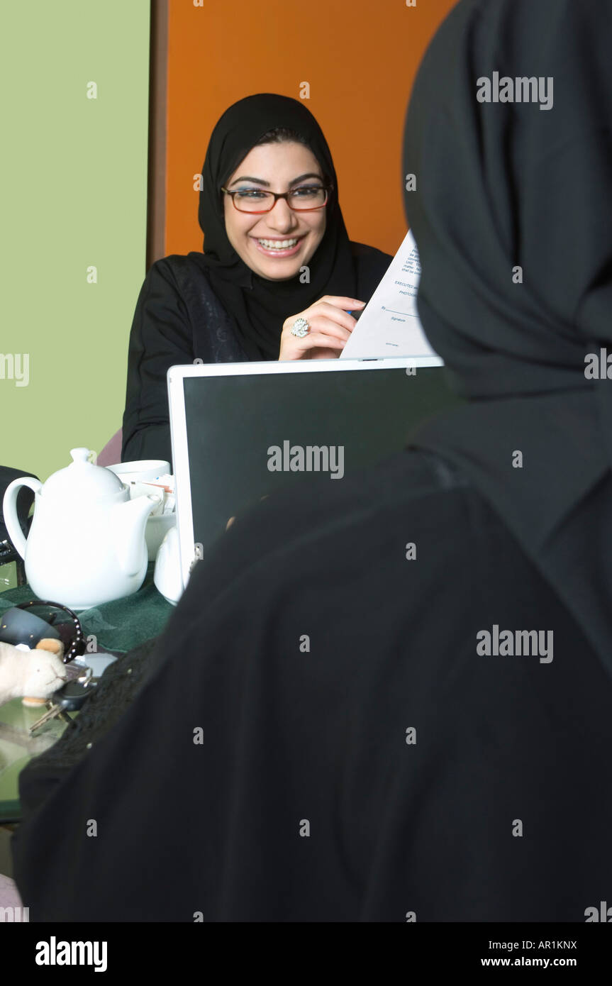 Arab Lady indoors working on a computer and talking Stock Photo - Alamy