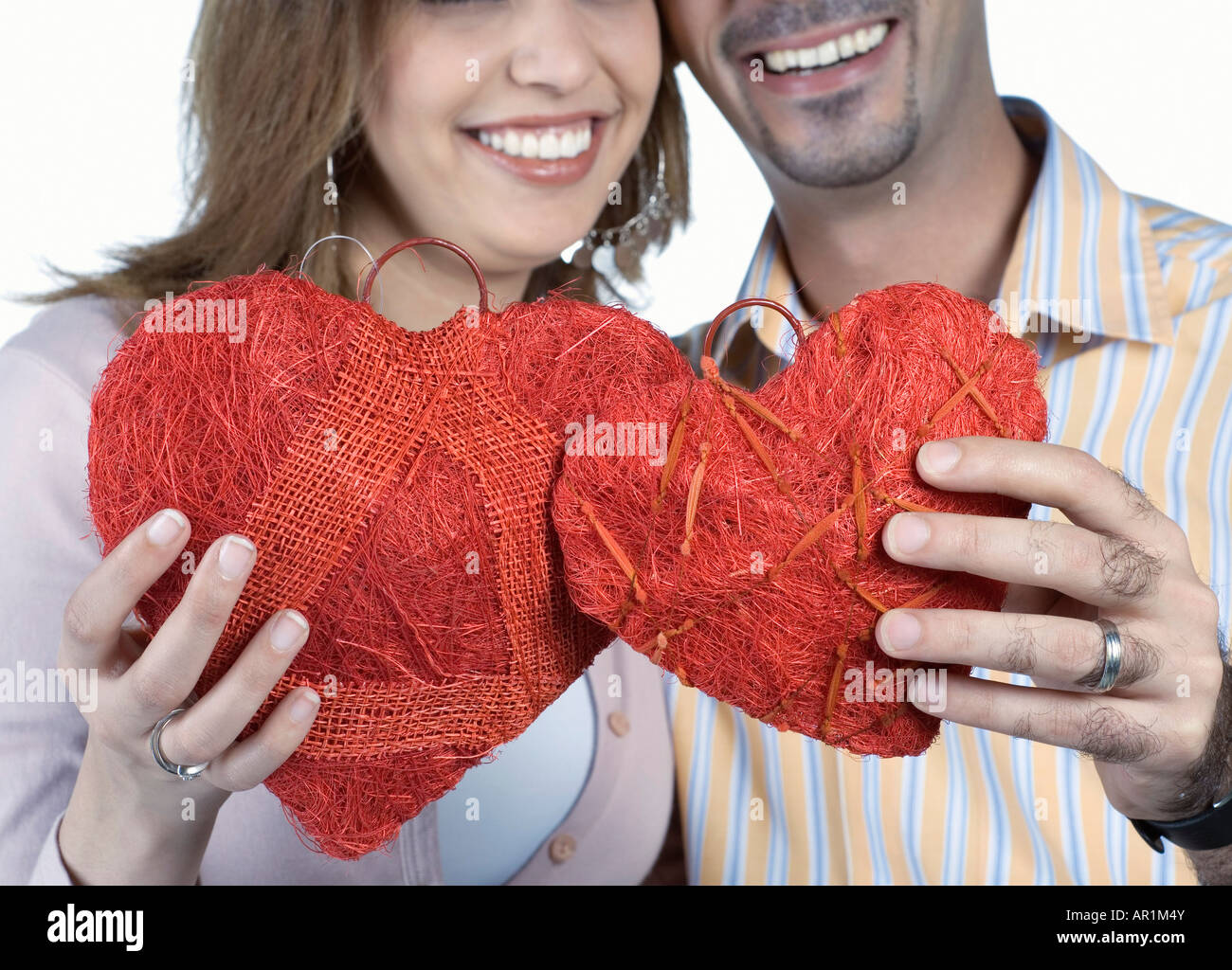 Young Couple holding heart shaped object Stock Photo - Alamy