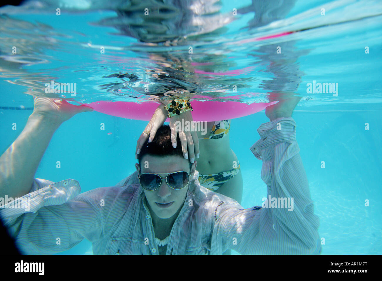 Woman pushing a man's head in the pool Stock Photo - Alamy