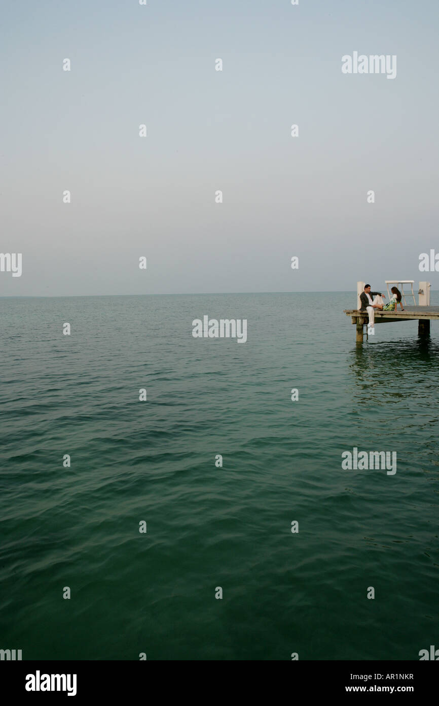 Young couple relaxing on pier Stock Photo - Alamy