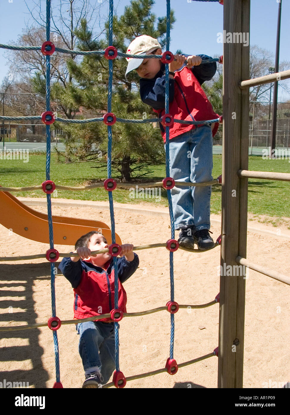 Five and three year old brothers climbing on playground equipment Stock ...