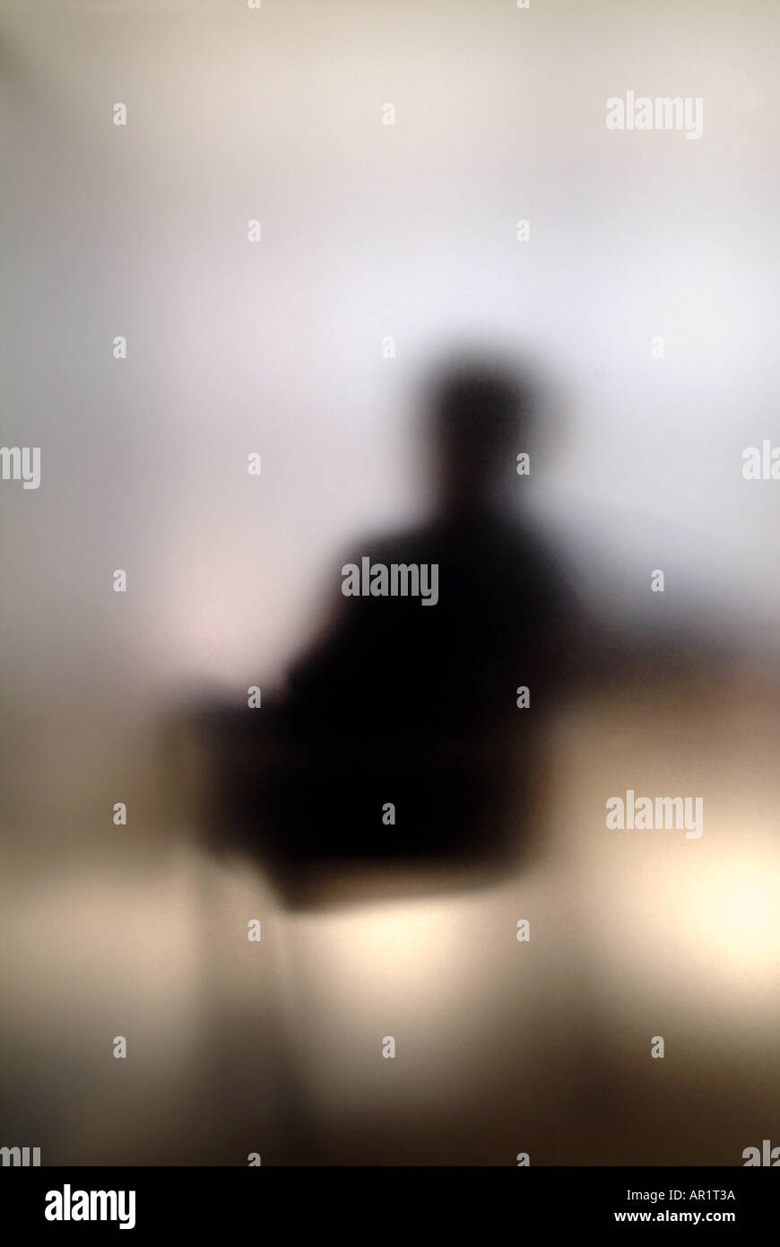 Man sat seated behind frosted glass screen image Stock Photo - Alamy