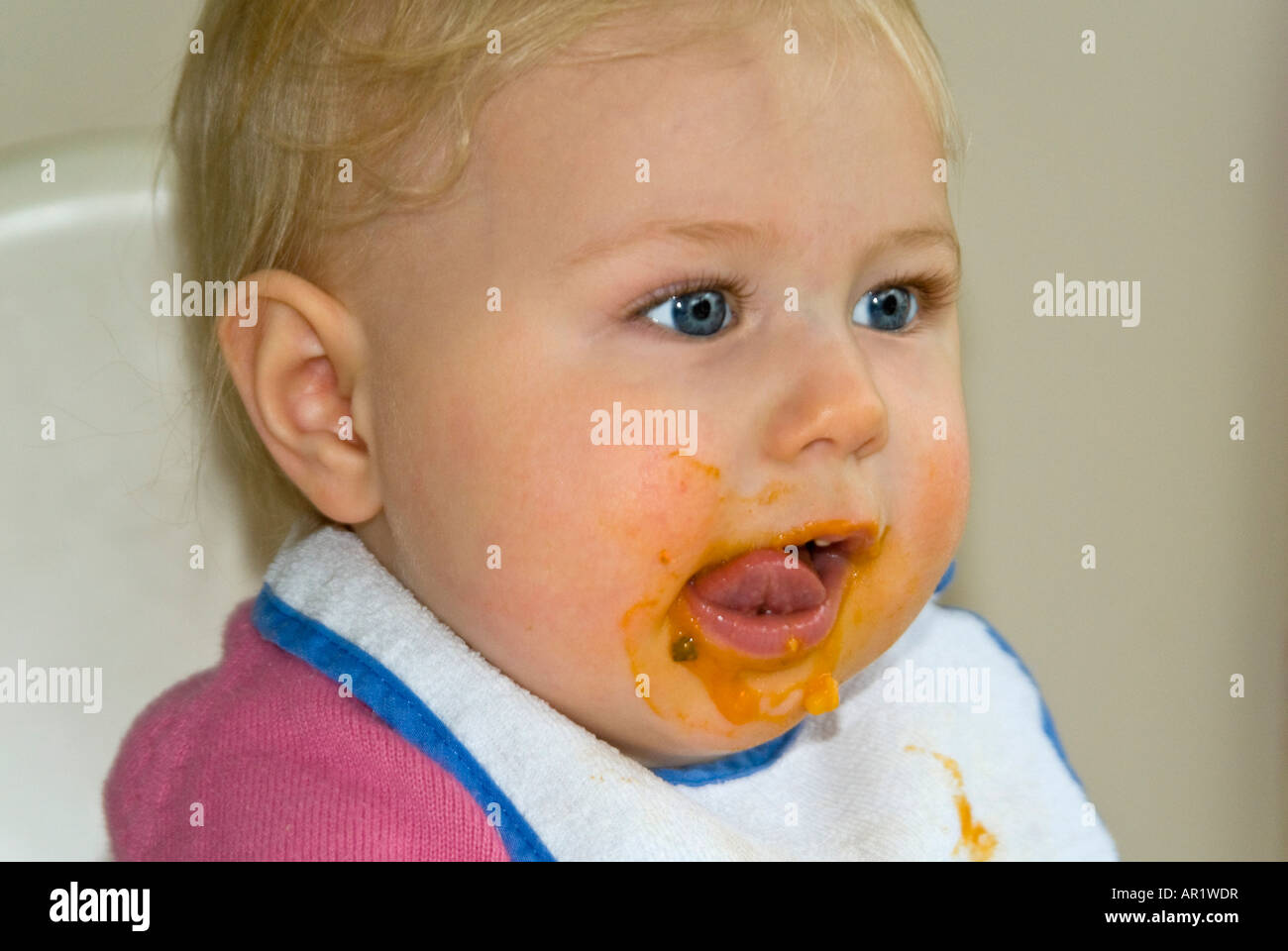 Horizontal close up of a pretty Caucasian baby girl sitting in her high ...