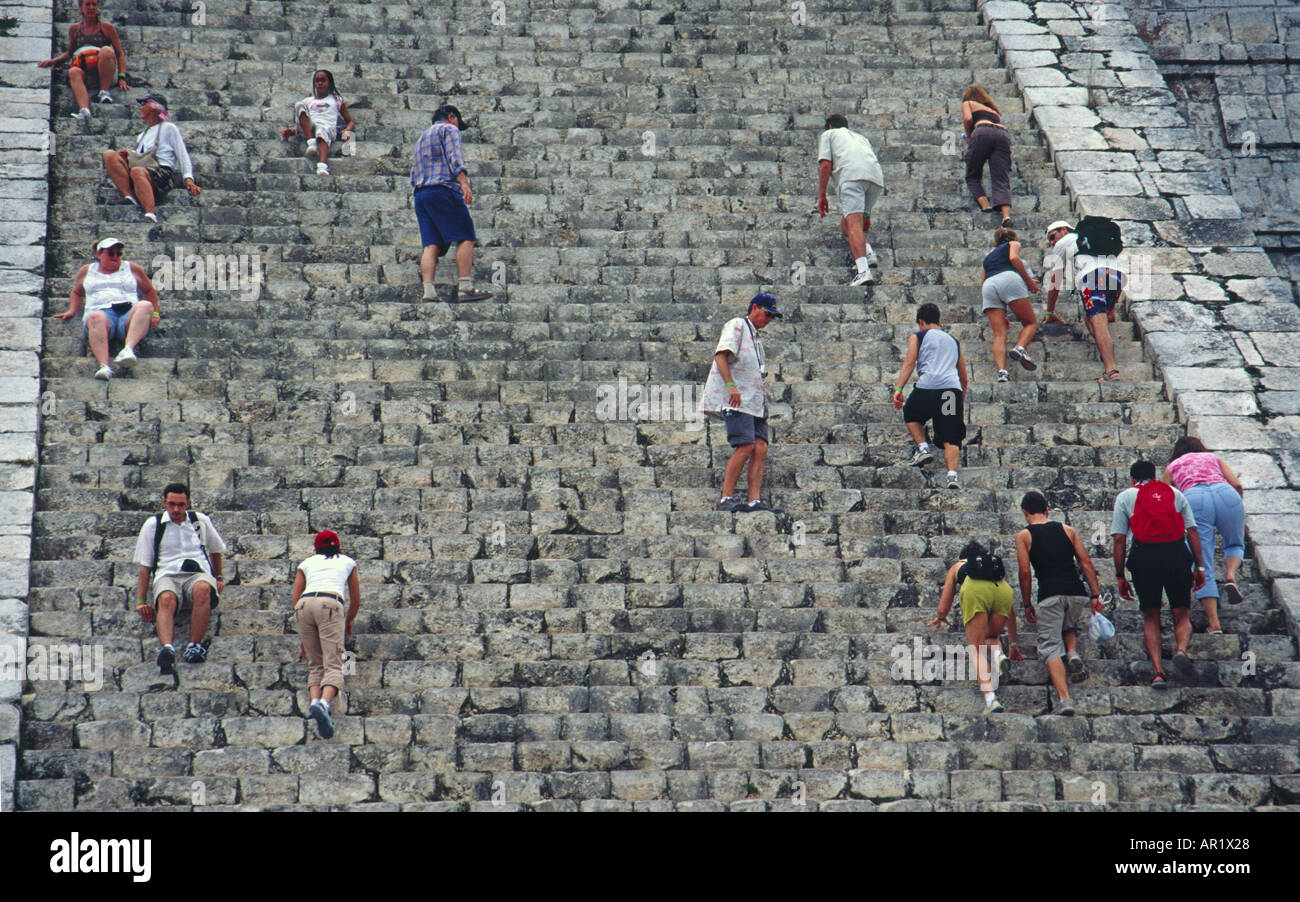 Tourists climbing the steep stairs of El Castillo Pyramid at Chichen ...