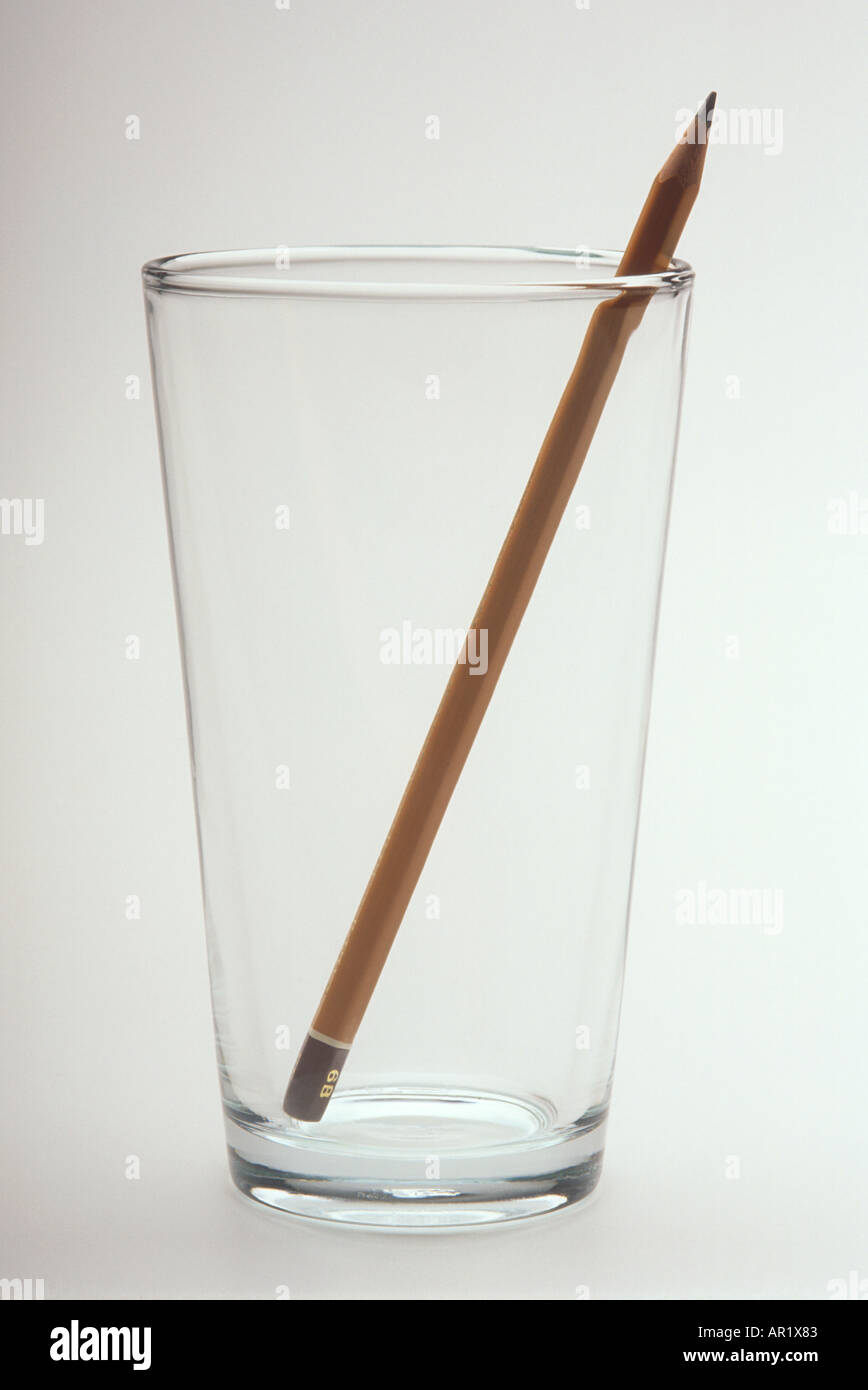 still life of one 1 pencil in empty water glass on plain background ...