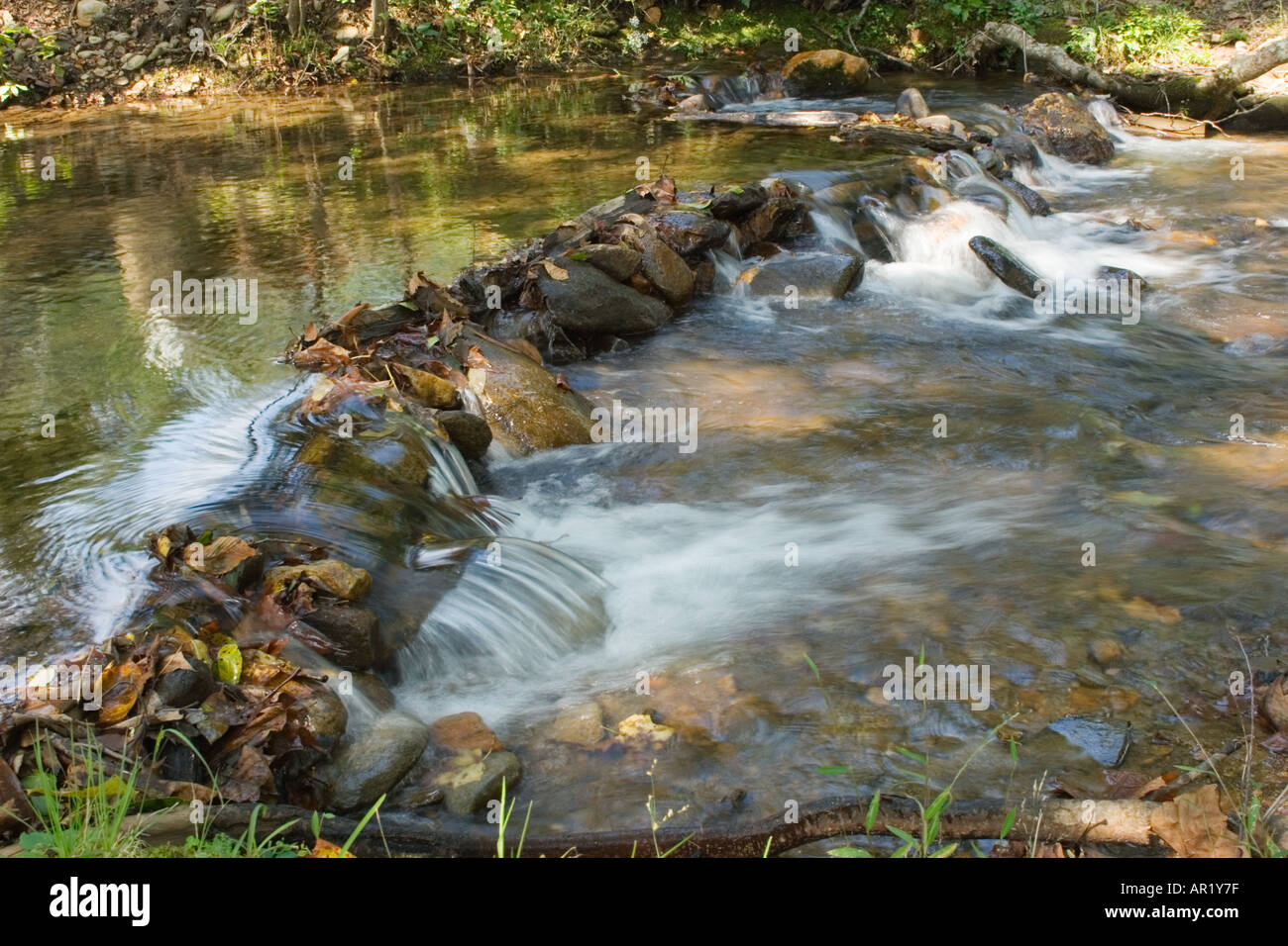 Stream water flows over and around rocks in small creek in north ...