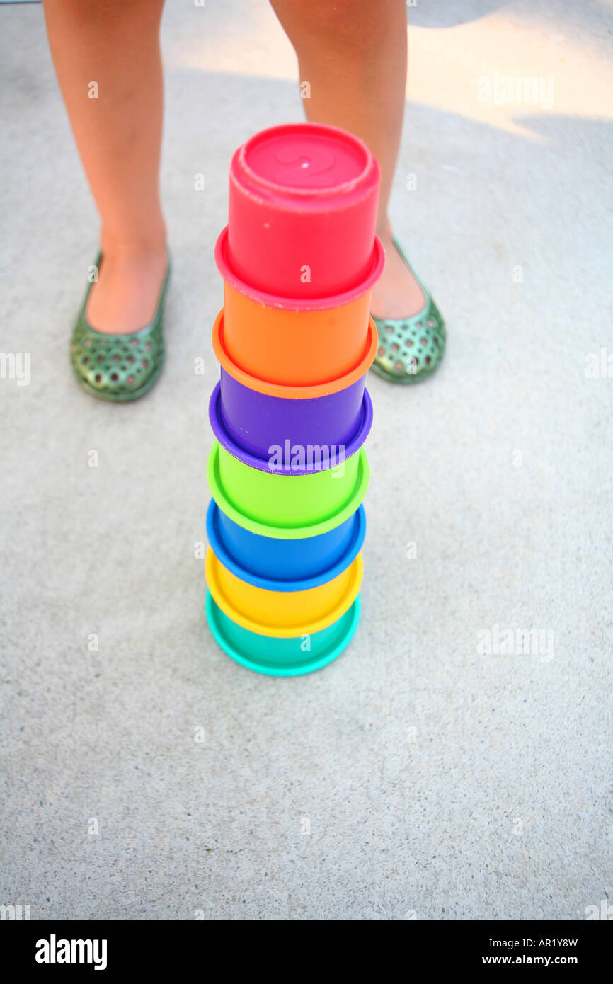 A child standing next to a stackable cups toy Stock Photo - Alamy