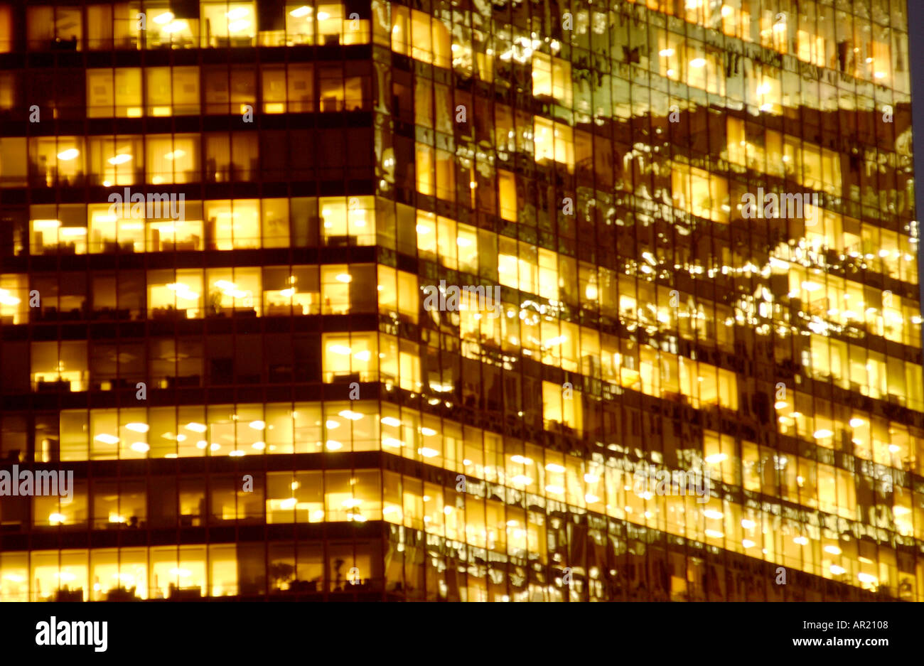 Horizontal color image of windows in a skyscraper illuminated at night ...
