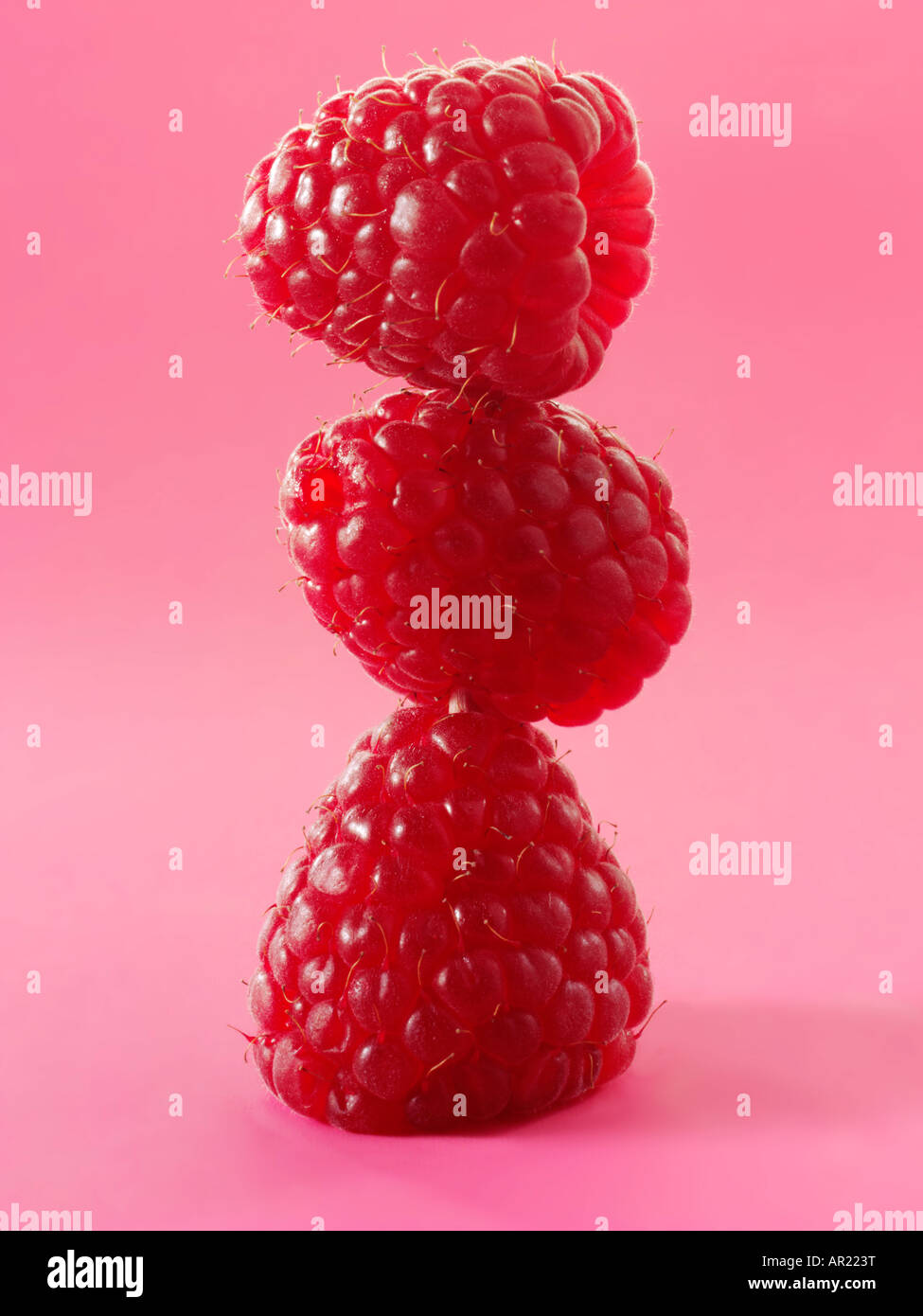 close up of a stylised stack of raspberries standing onto of each other ...