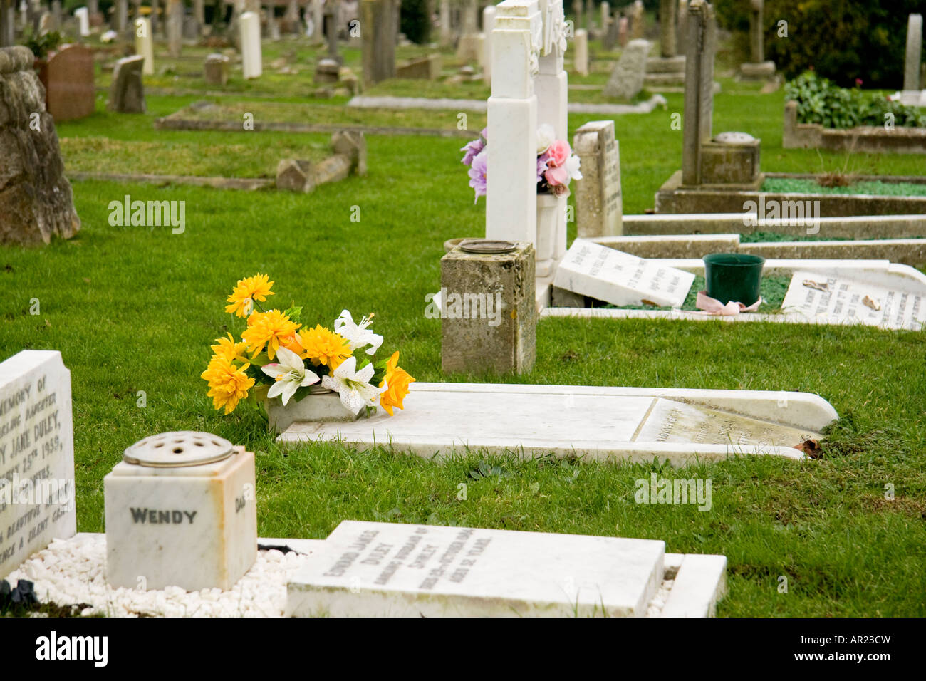 Flowers on graves surrounded by grass in an English cemetery Stock ...
