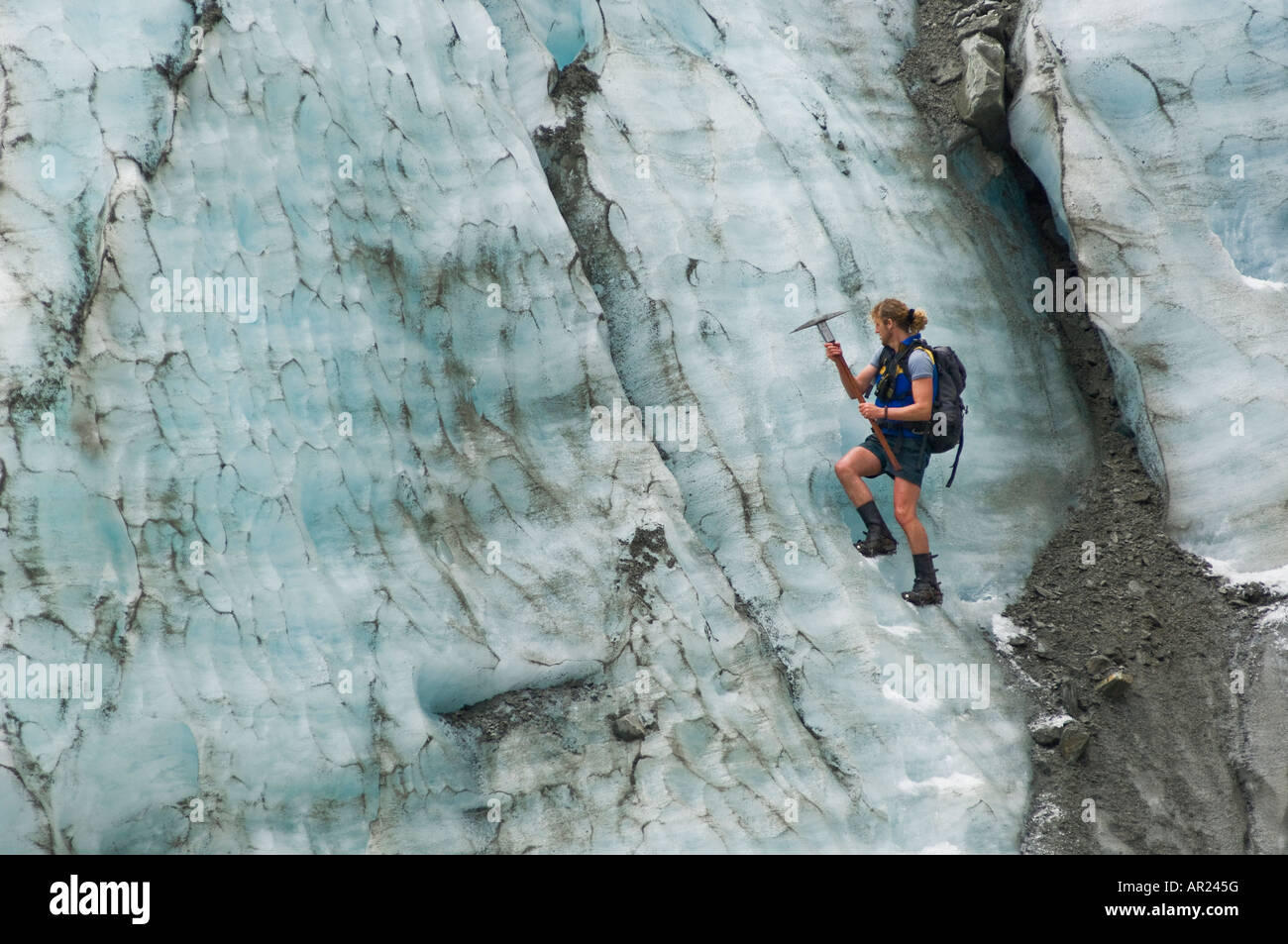 Glacier Guide cutting steps in ice of Franz Josef glacier, New Zealand ...
