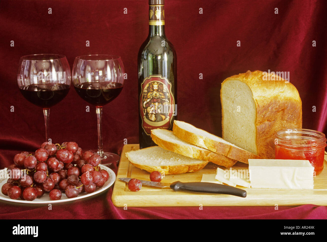 Still life table setting of bread, wine, cheese, jam, grapes Stock ...
