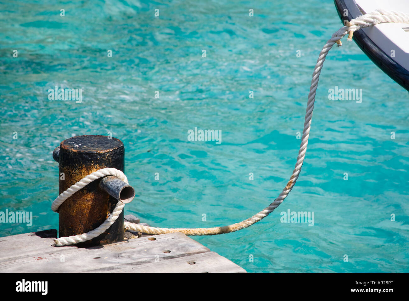 Mooring bollard on a jetty with rope attached Stock Photo - Alamy
