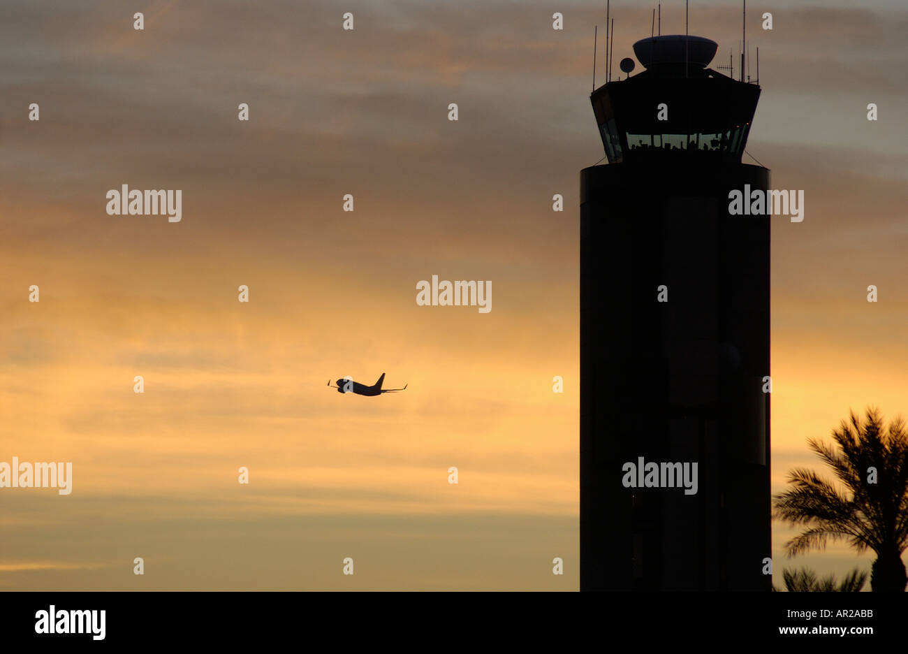 Airliner taking off past Control tower at Sunset Stock Photo - Alamy