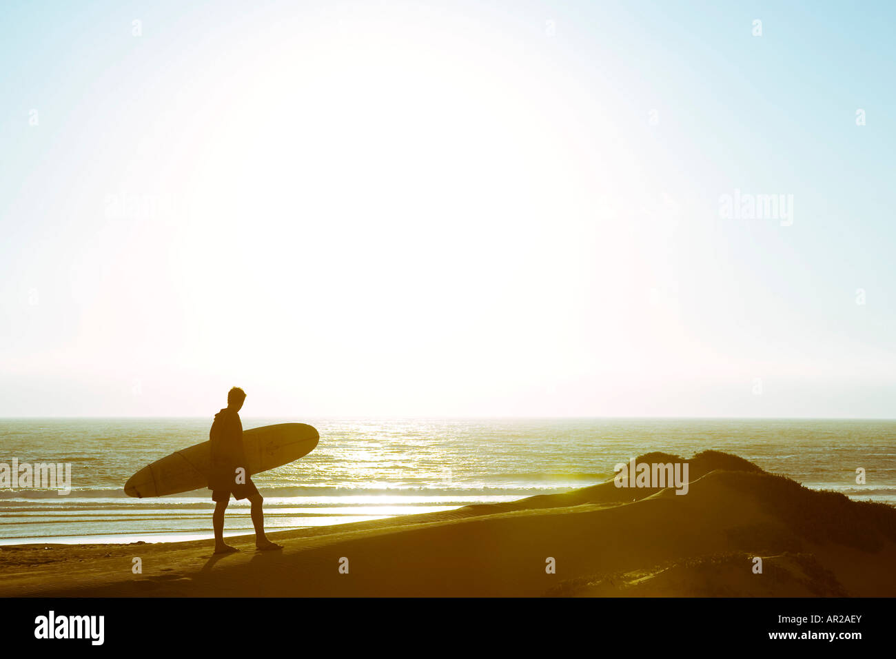 Surfer walking on the beach in Baja Mexico Stock Photo - Alamy
