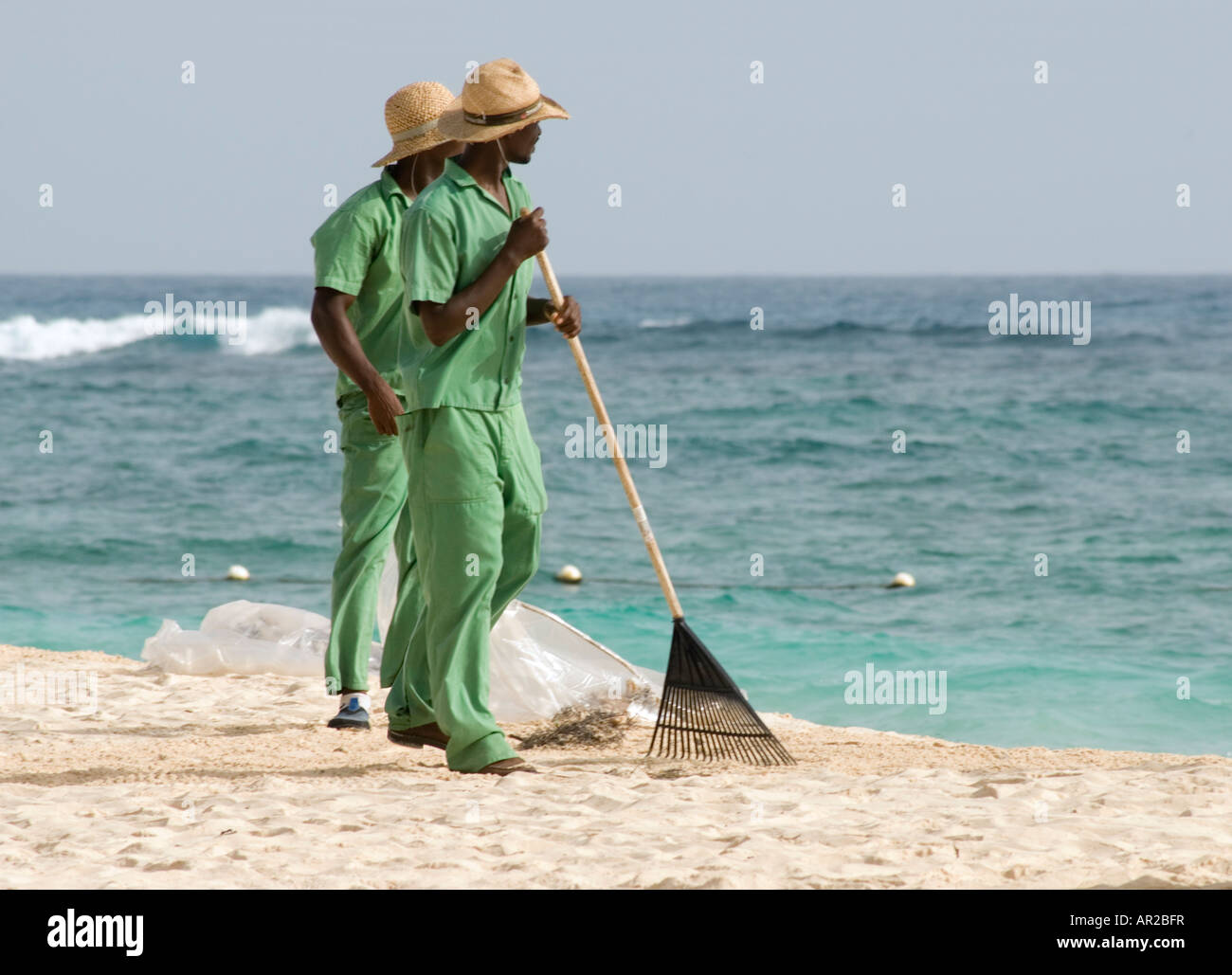 Two hotel workers on the beach at a resort in Punta Cana, The Dominican ...