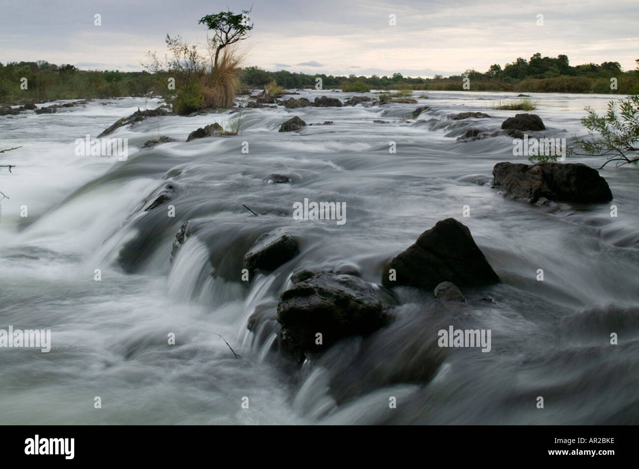 Africa Namibia The Okavango River flows over Popa Falls at dusk in the ...