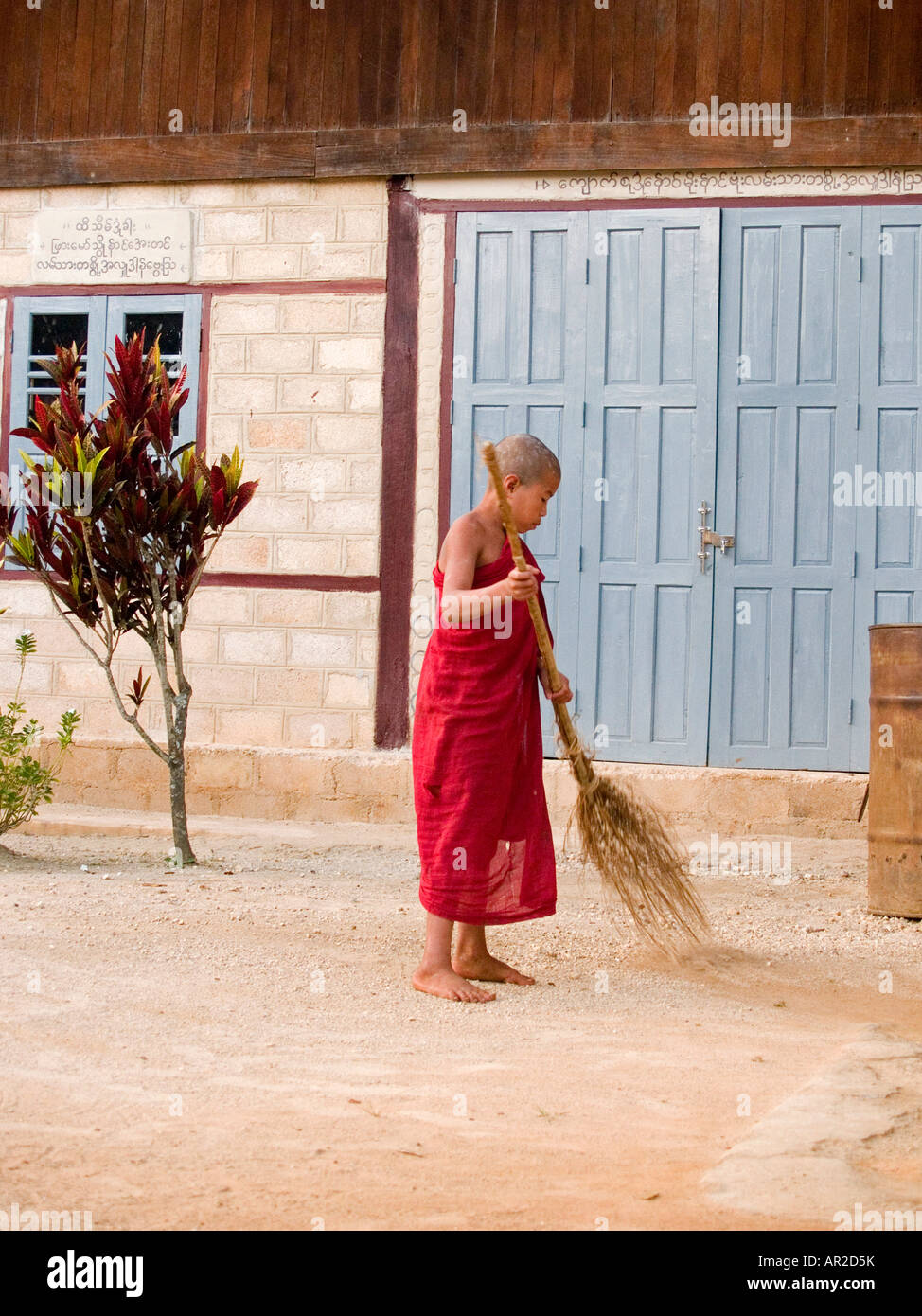 Young Burmese monk sweeping at his monastery Stock Photo - Alamy