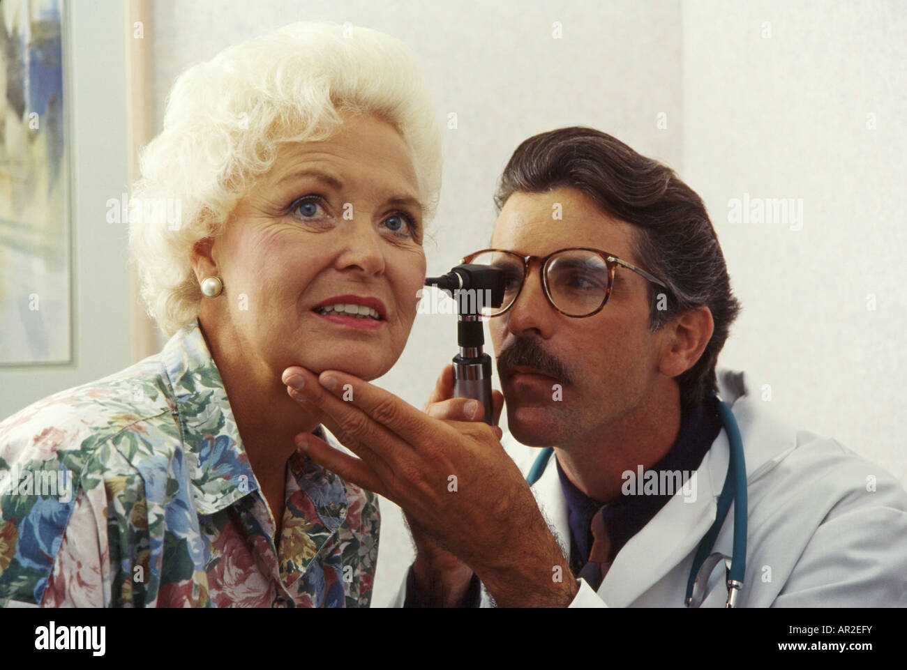 Doctor giving physical exam to seniors, Miami Stock Photo - Alamy