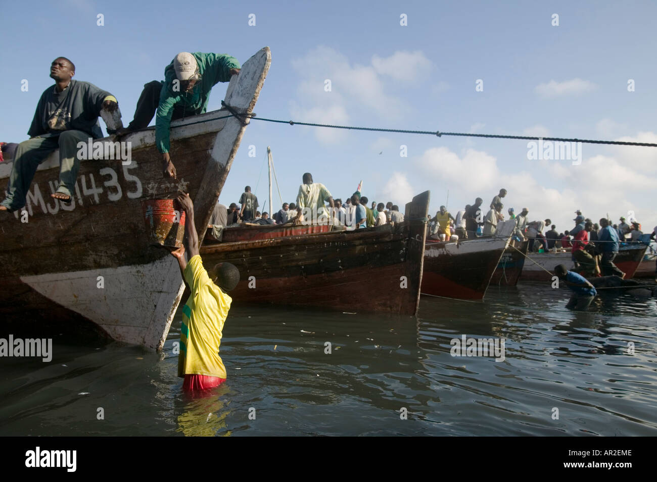 Africa Tanzania Zanzibar Stone Town Morning sun lights man carrying ...