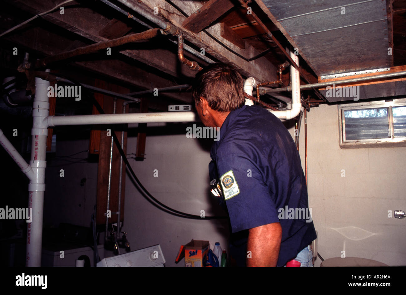 Plumber checking that pipes in basement have the proper grade/slope per ...