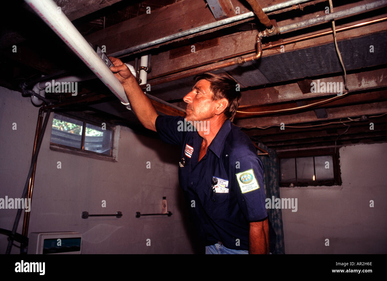 Plumber checking that pipes in basement have the proper grade/slope per ...
